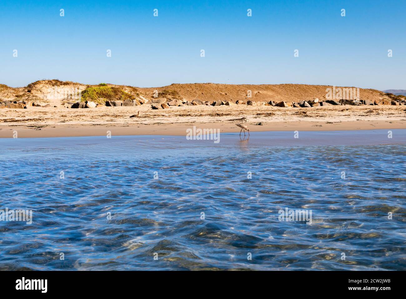 Sand dunes on the beach, crystal clear blue water with beautiful sun ...