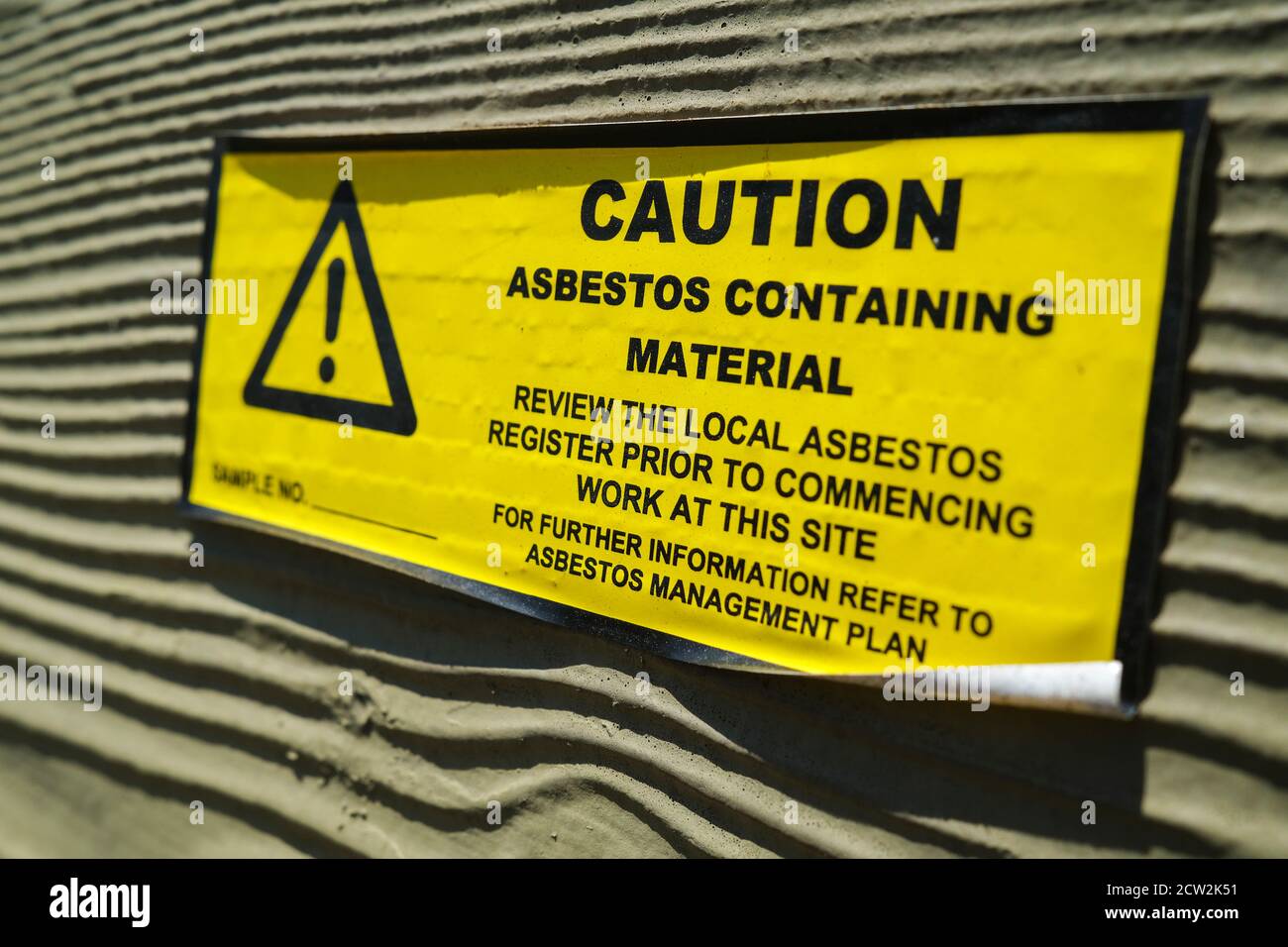 Caution Asbestos sticker on the outside wall of a construction Stock ...