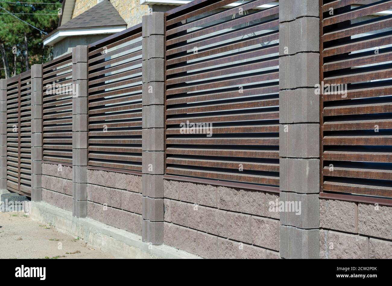 Blinds fence with gray stone columns. A brown outer fence around the ...