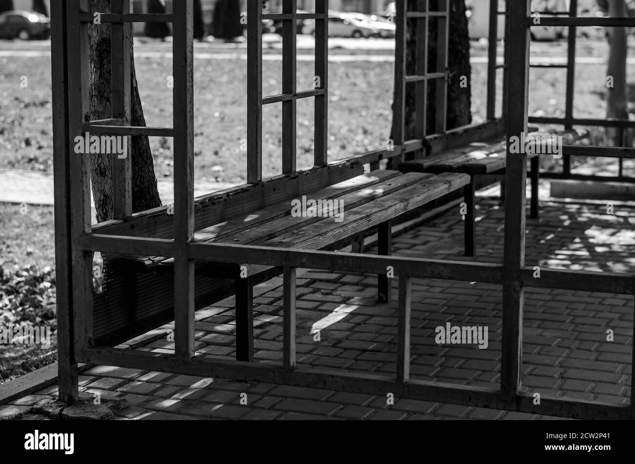 Empty bus stop with wooden benches. Black and white photo of a suburban ...
