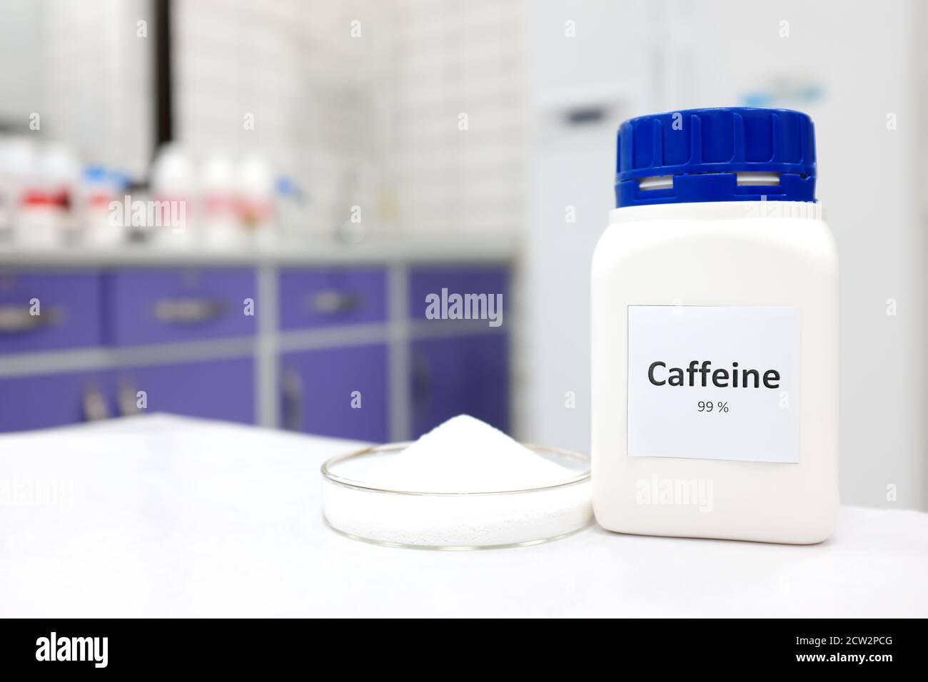 Selective focus of a bottle of pure caffeine chemical compound beside a ...