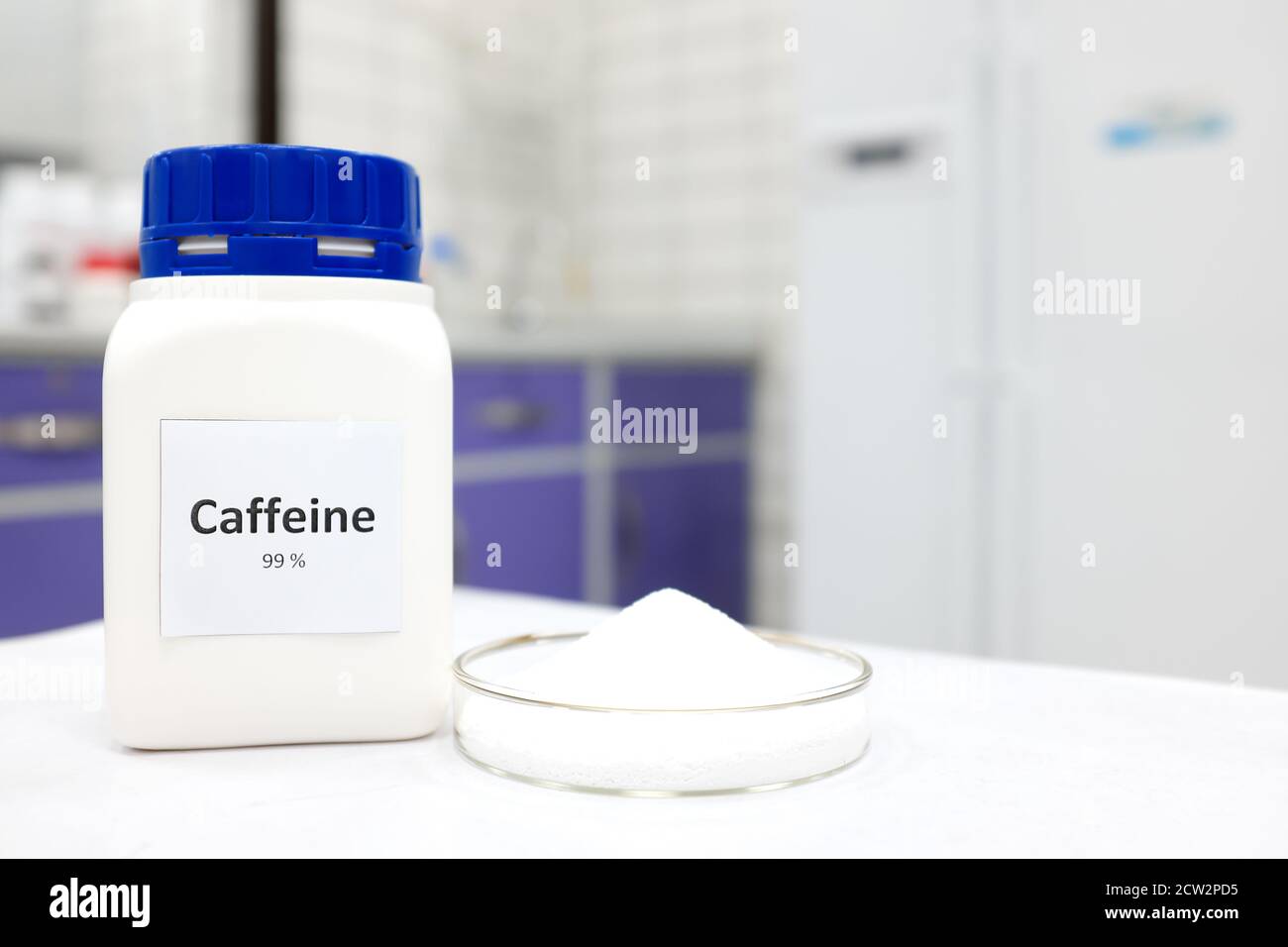 Selective focus of a bottle of pure caffeine chemical compound beside a ...