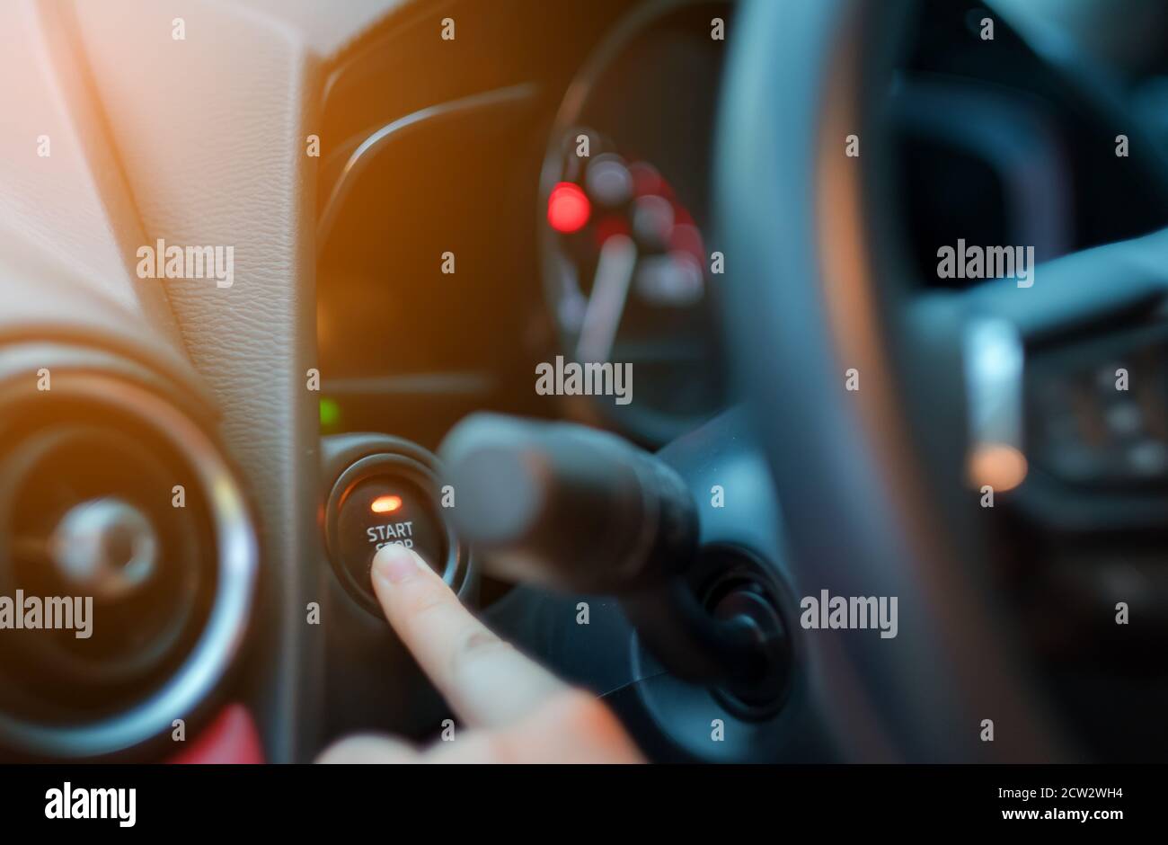 closeup hand pushing on car start engine, Woman driver pushing a start ...