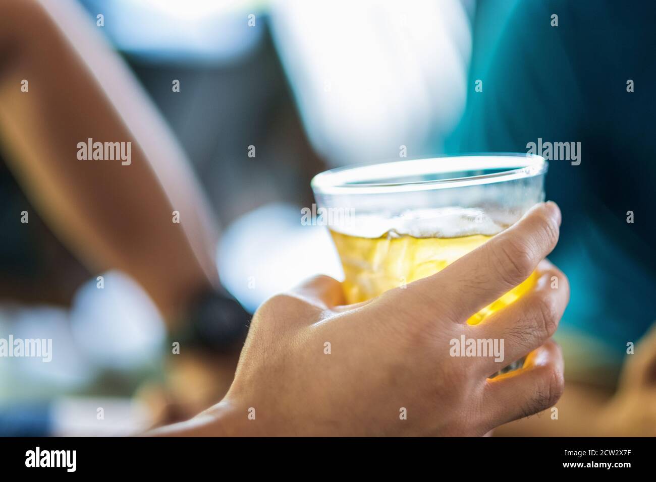 Hand holds a glass of ice tea. Drink Tea relax cosy photo with blurred ...