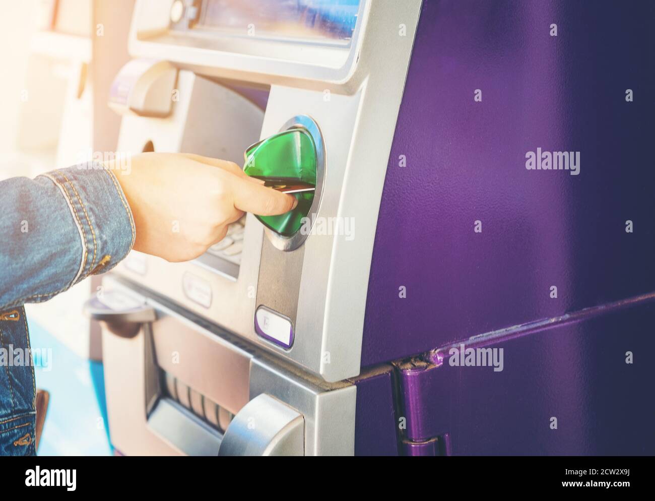 Women nand inserting ATM credit card into bank machine Stock Photo - Alamy