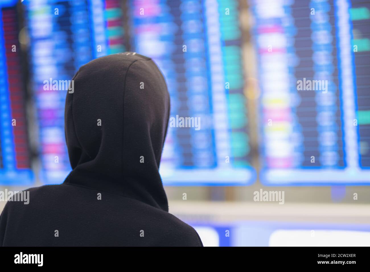 back view of young man in airport near flight timetable, hacker ...