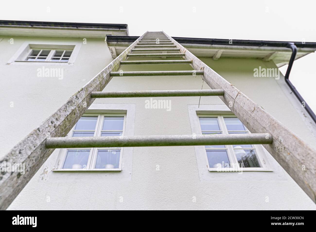 metal ladder standing high against roof gutter Stock Photo - Alamy