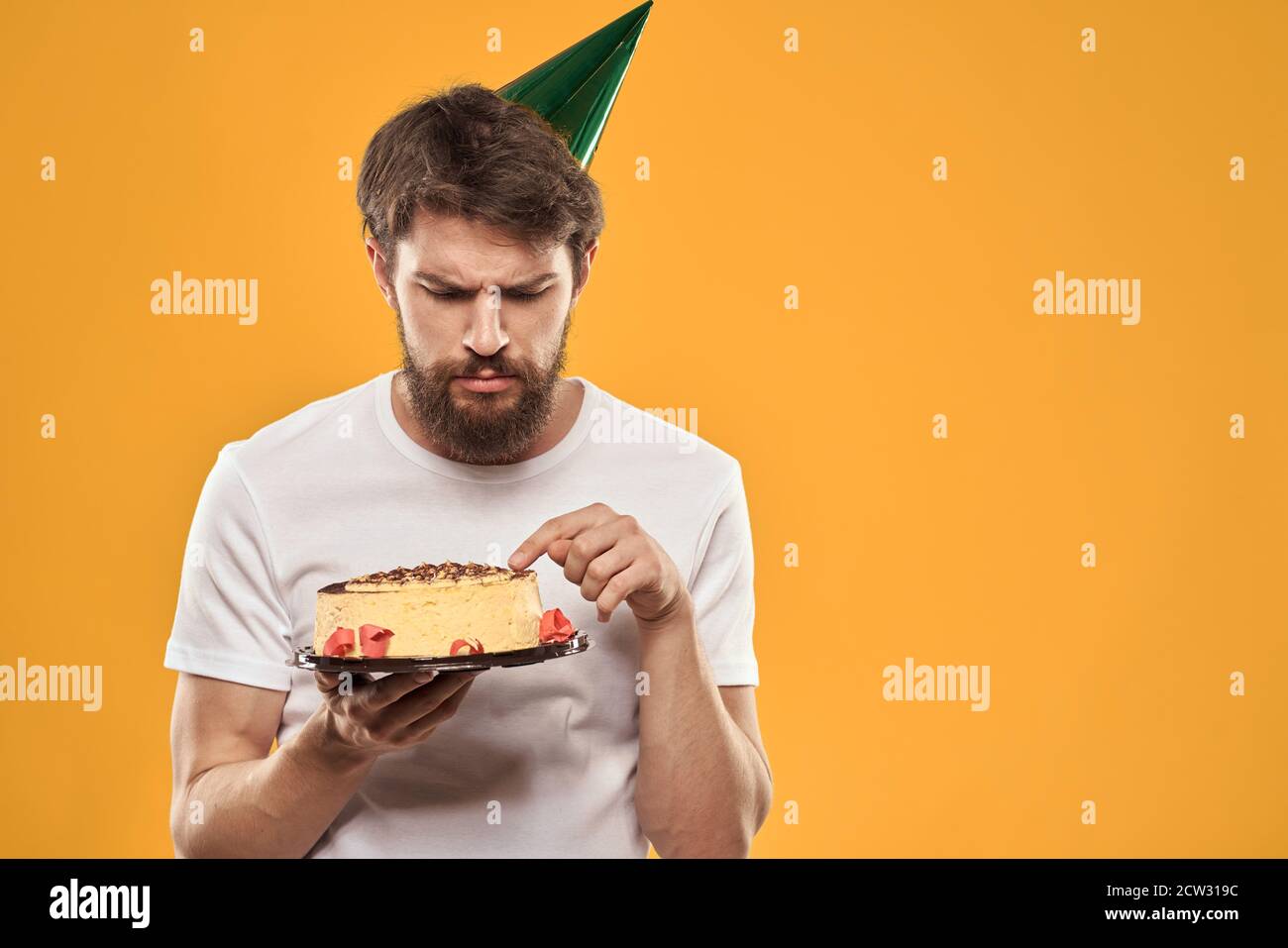 A bearded man with a cake and in a cap celebrating his birthday Stock ...