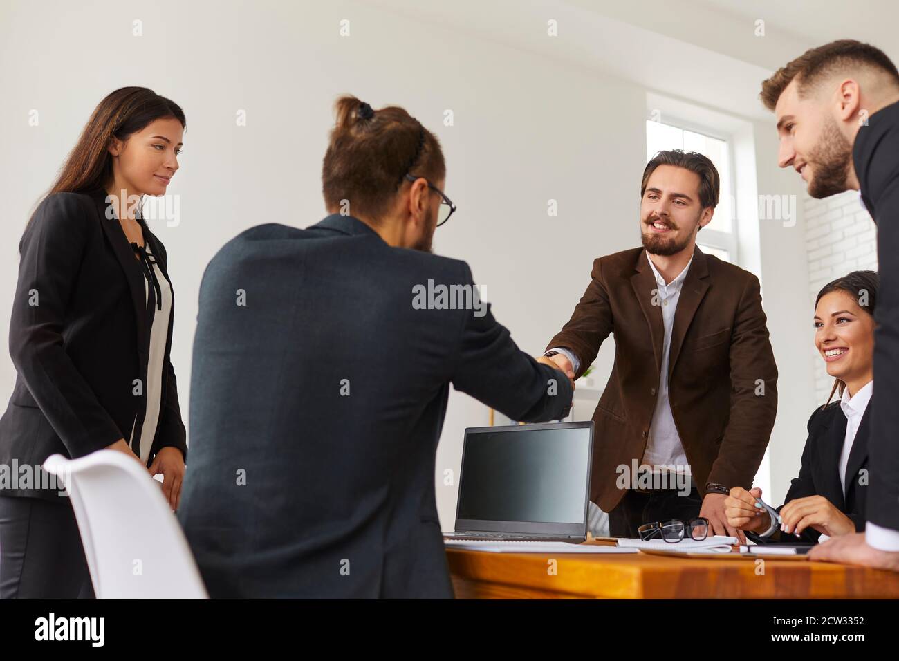 Young business partners making deal and shaking hands after successful ...