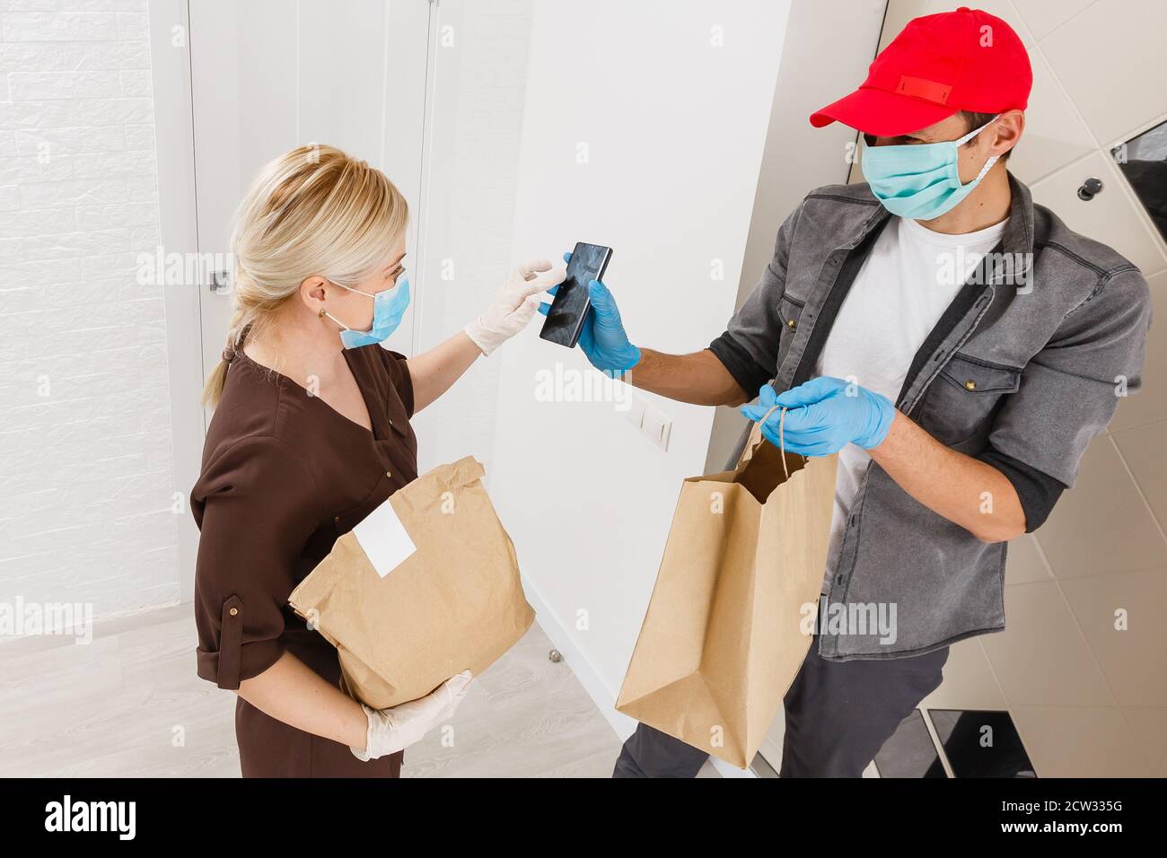 Delivery man holding paper bag with food on white background, food ...