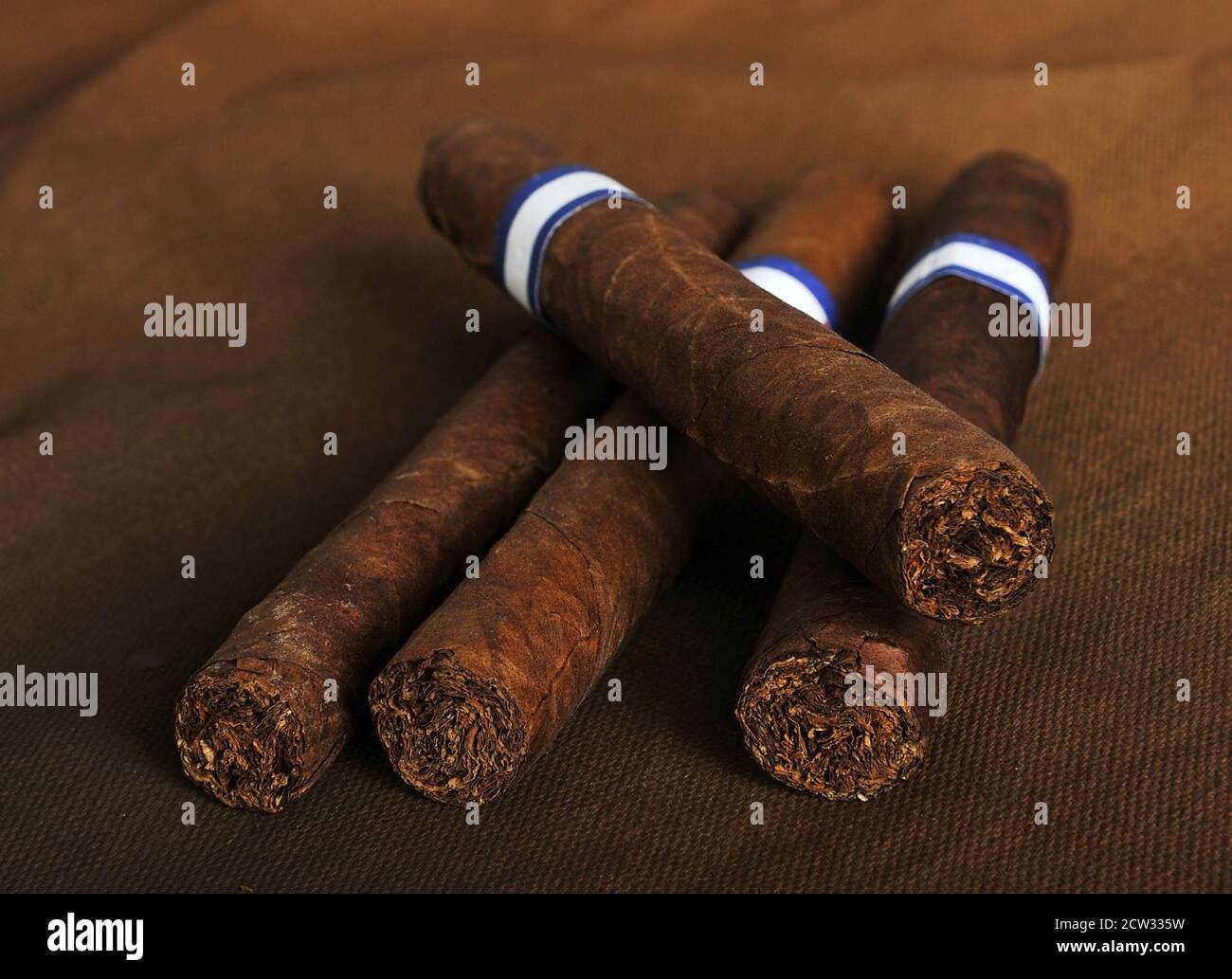 Detailed photo of cigars on the brown background Stock Photo - Alamy