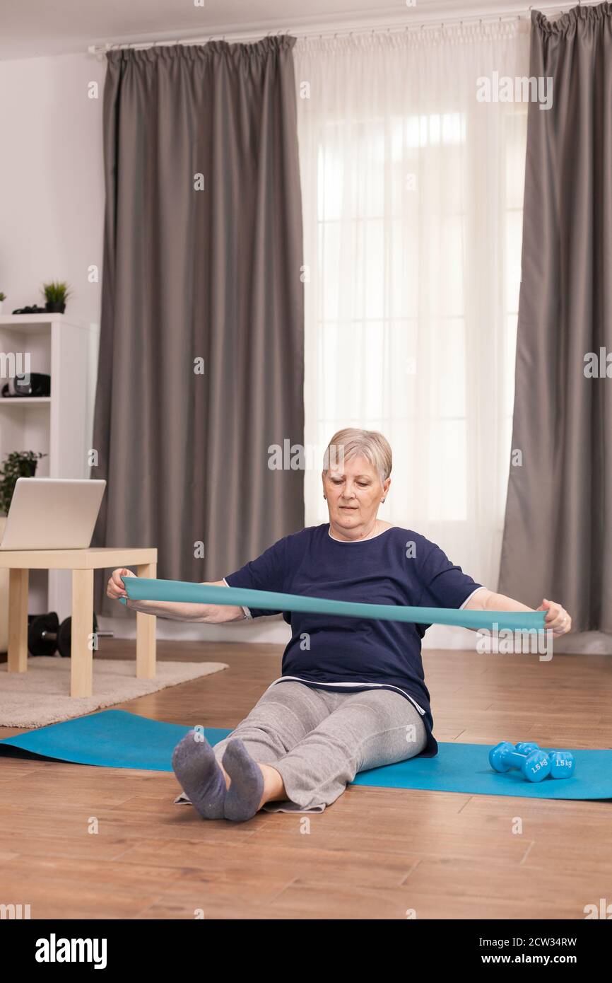 Strong old woman doing fitness for recovery at home. Old woman lifting ...