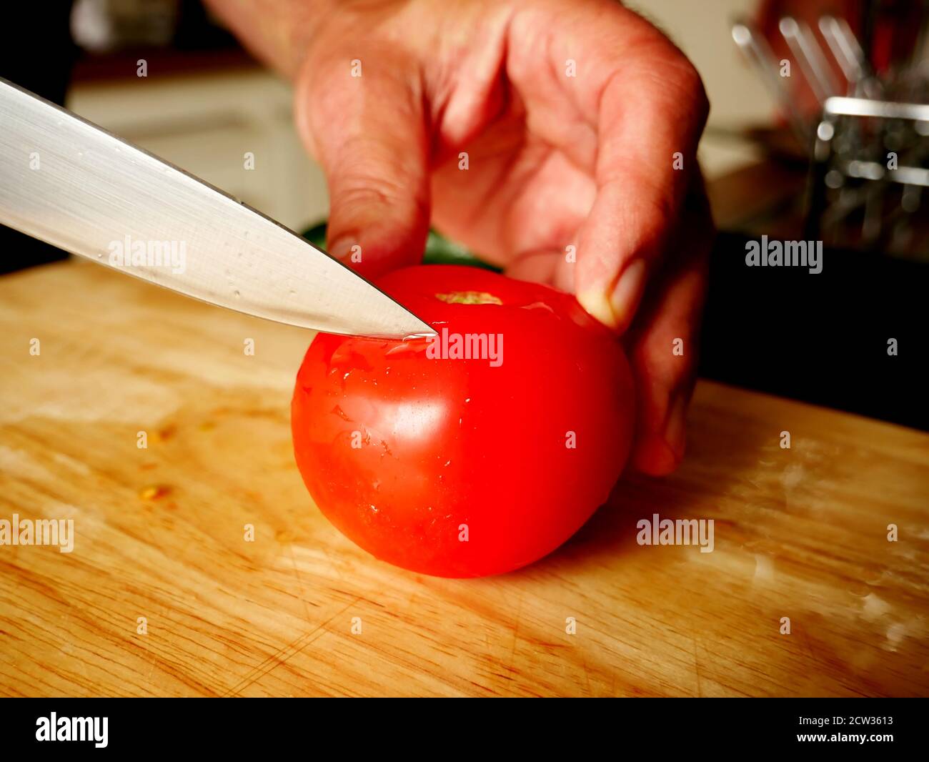 Closeup of the hand, the knife and the tomao Stock Photo - Alamy