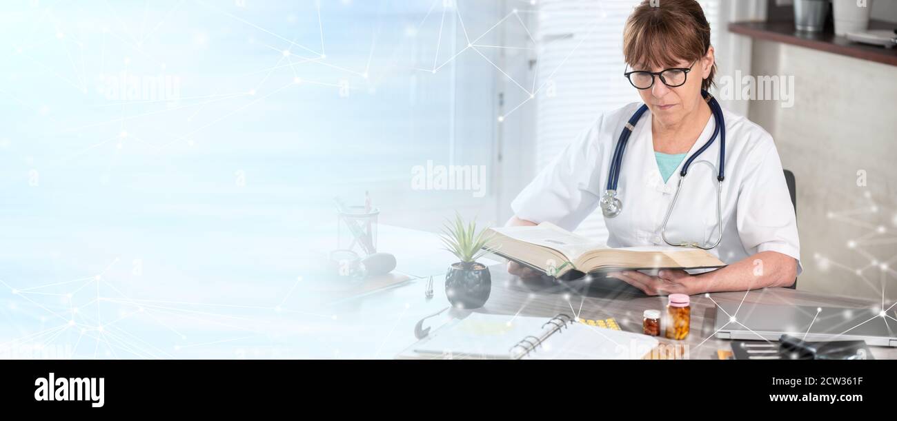 Female doctor reading a textbook in medical office; panoramic banner ...