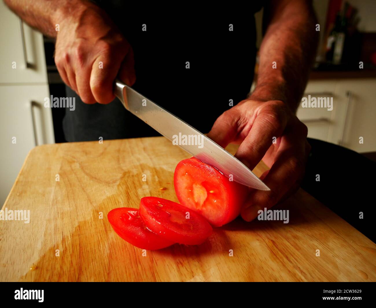 Closeup of the hand, the knife and the tomao Stock Photo - Alamy