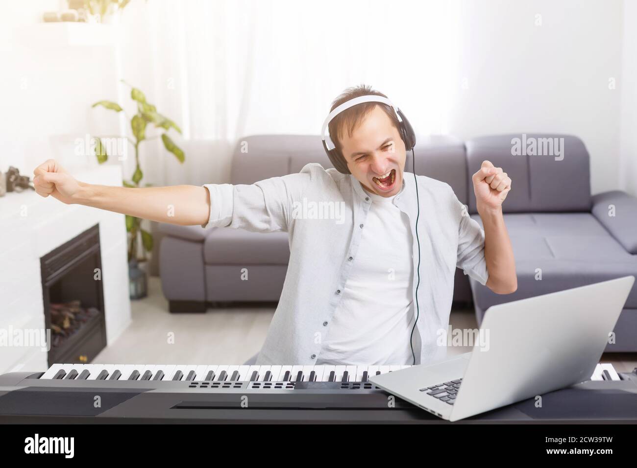 Man playing music with piano and laptop Stock Photo - Alamy