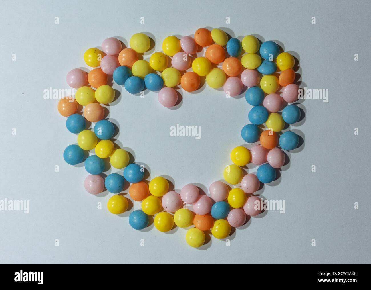 Colorful round candy heart frame on white background, sweets color ...