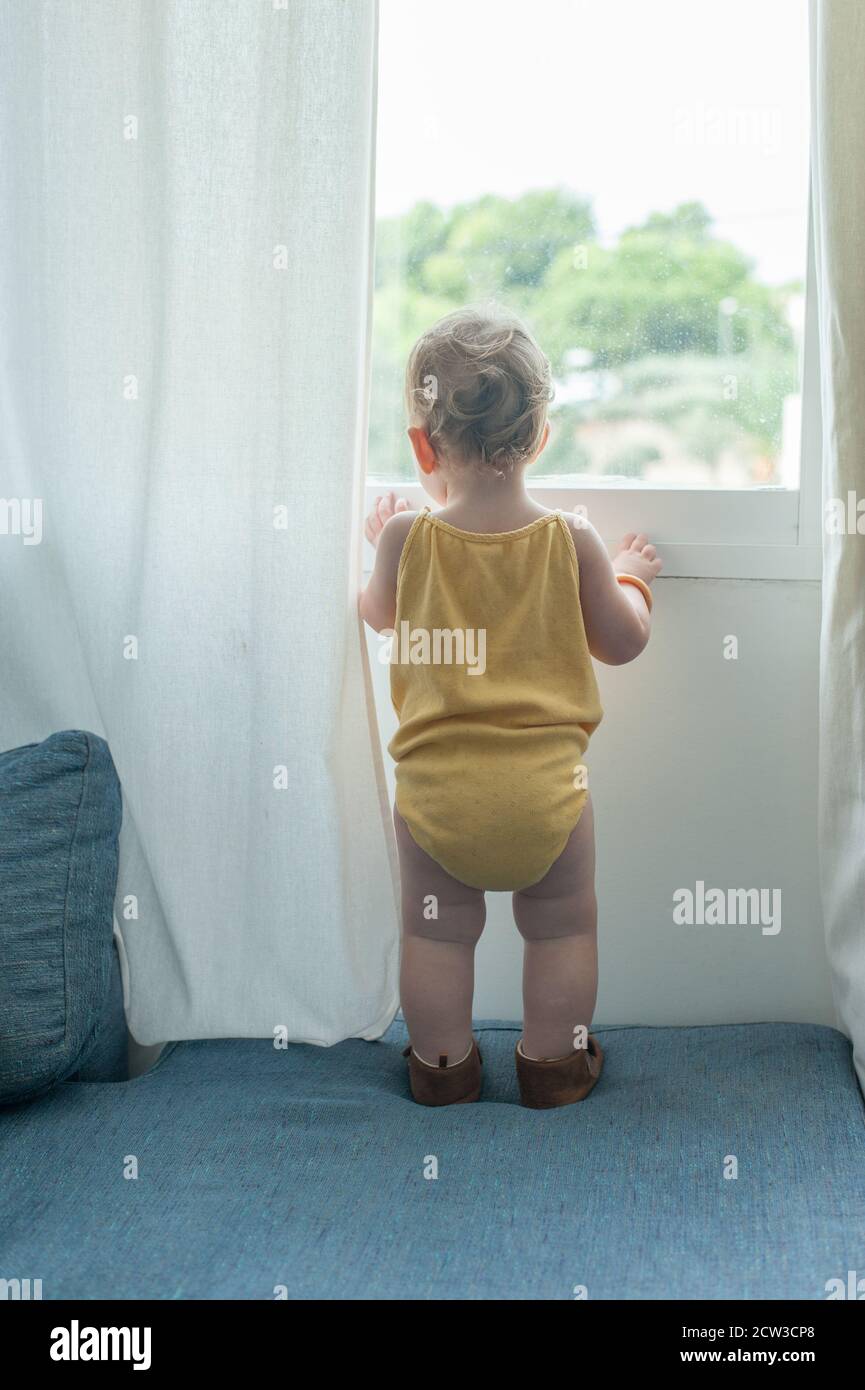 baby looking through window Stock Photo - Alamy