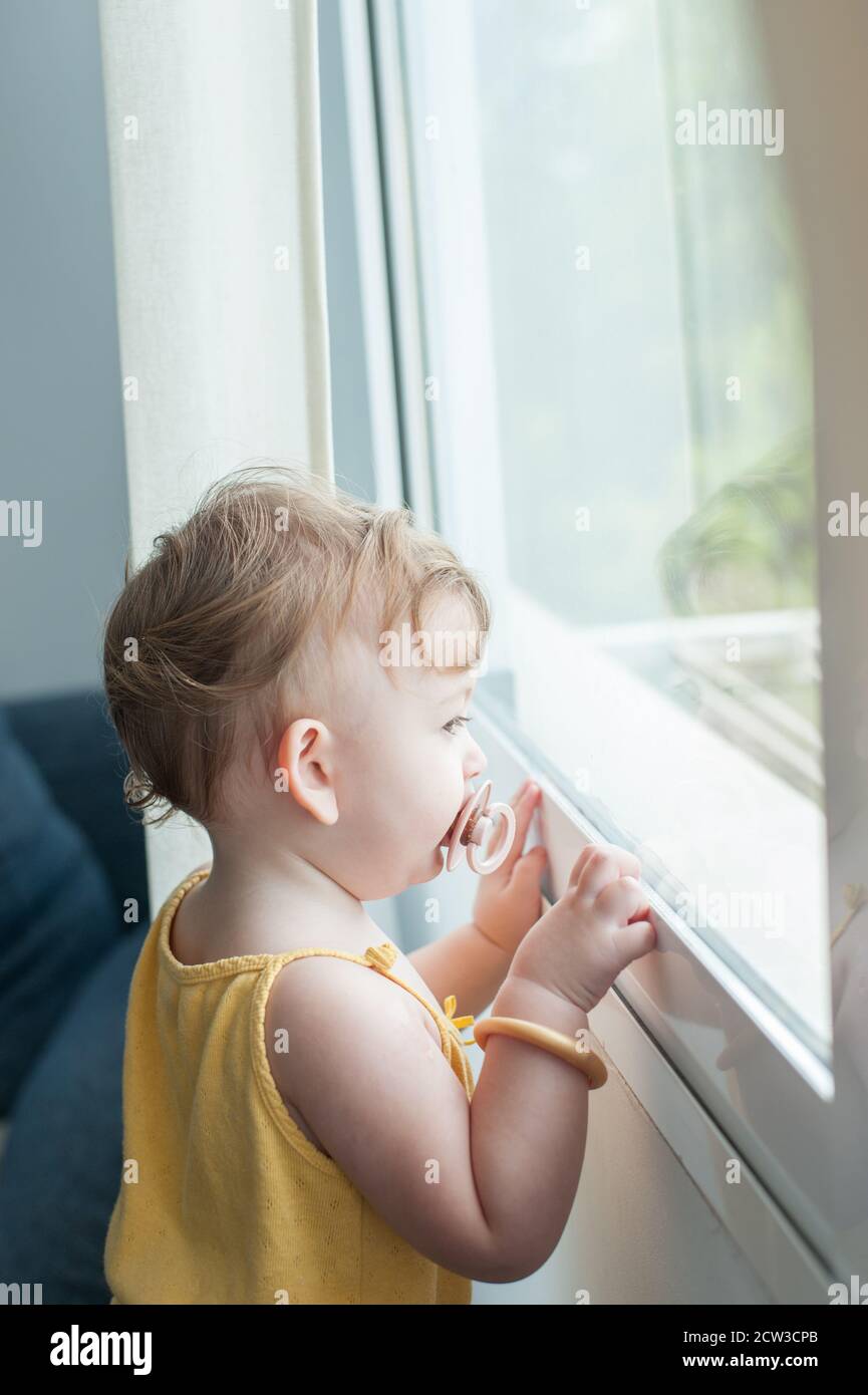 baby looking through window Stock Photo - Alamy