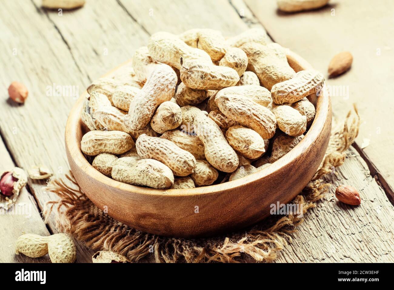 Peanuts in shell in a wooden bowl, selective focus Stock Photo - Alamy