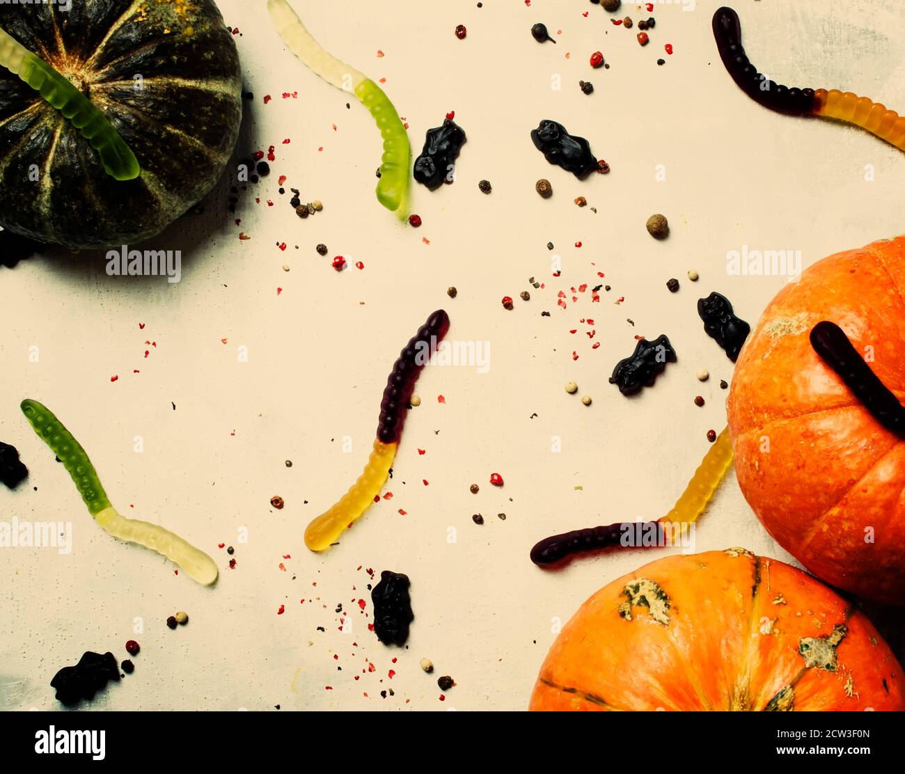 Halloween background, pumpkins, worms and black candy, toned image, top ...