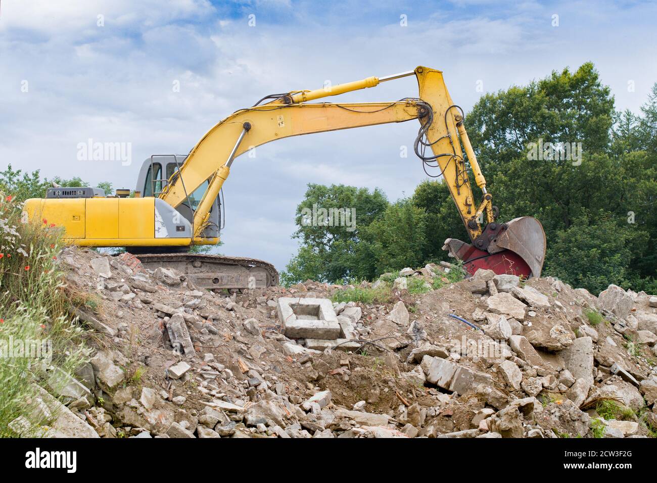 Modern excavator clears the debris of a building after an earthquake ...
