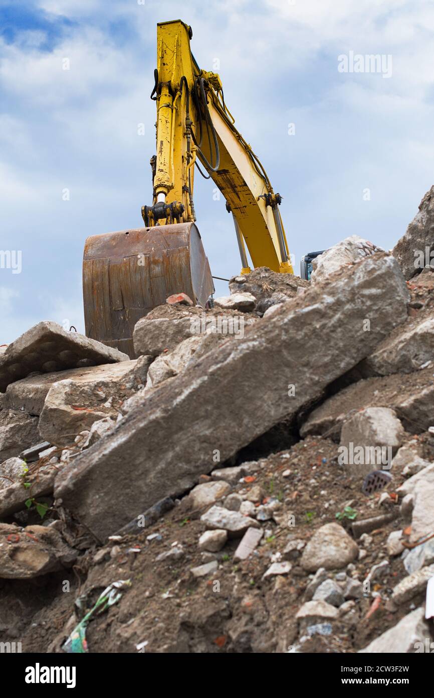 Modern excavator clears the debris of a building after an earthquake ...