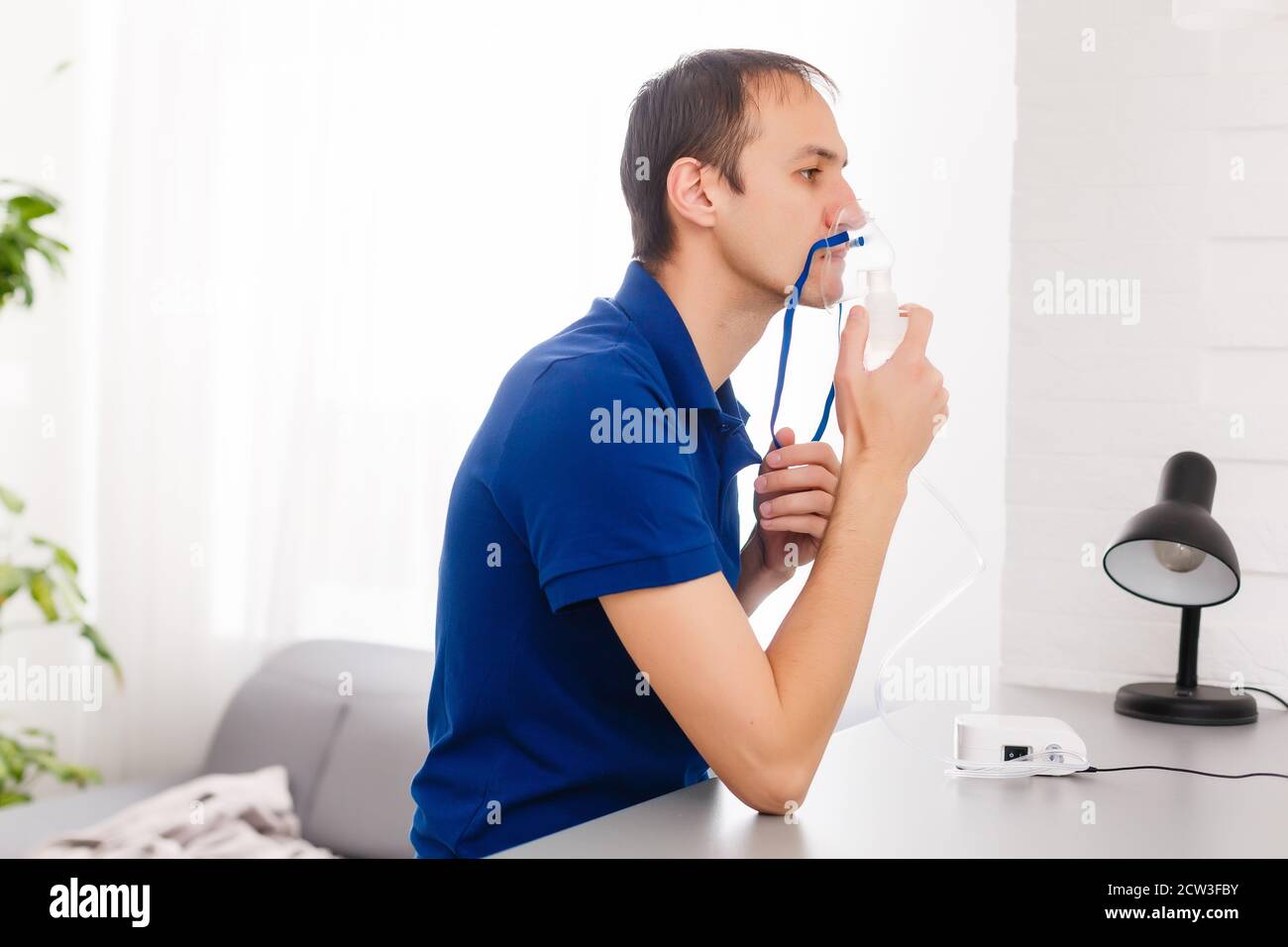 Portrait Of Young Man Inhaling Through Inhaler Mask Stock Photo - Alamy