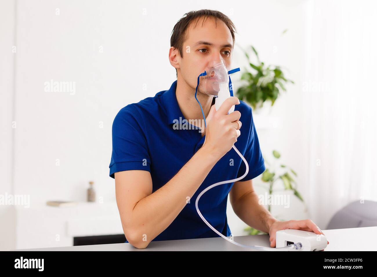 Portrait Of Young Man Inhaling Through Inhaler Mask Stock Photo - Alamy