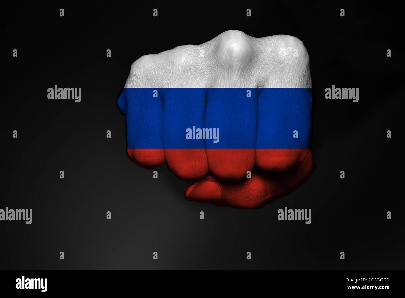 Low key picture of a fist painted in colors of Russian flag on a black ...
