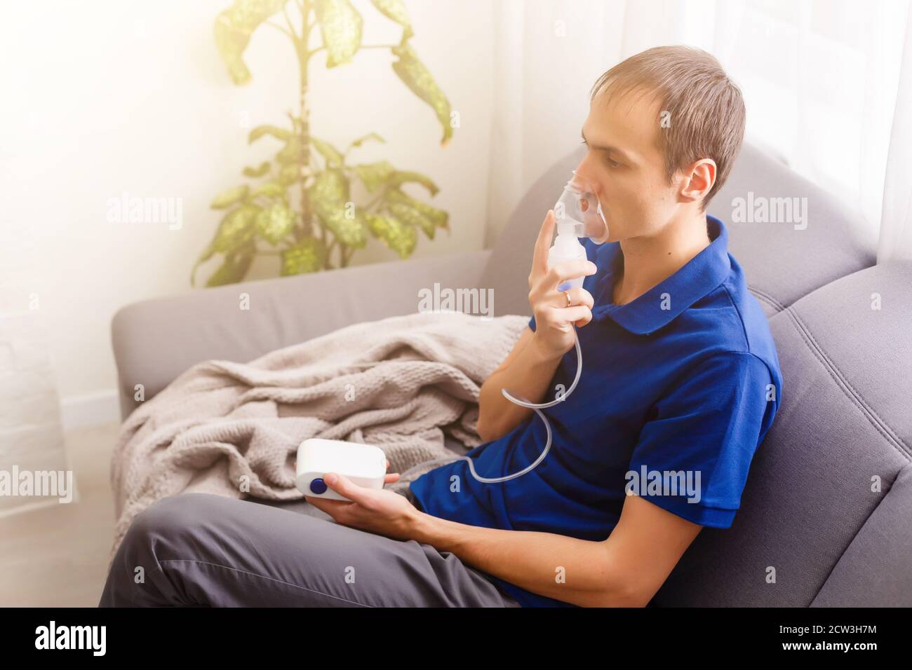 Portrait Of Young Man Inhaling Through Inhaler Mask Stock Photo - Alamy