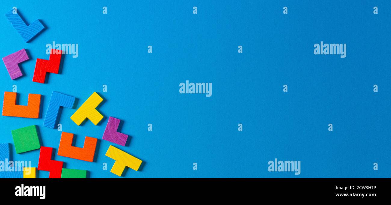 Different colorful shapes wooden puzzle blocks on light blue background ...