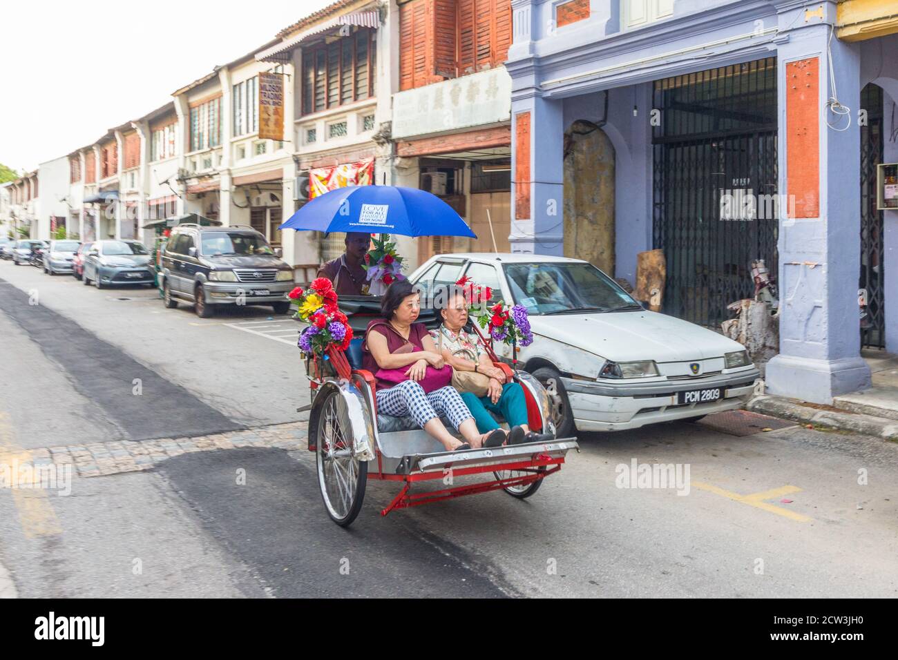 Tourists riding a rickshaw in Penang, Malaysia Stock Photo - Alamy