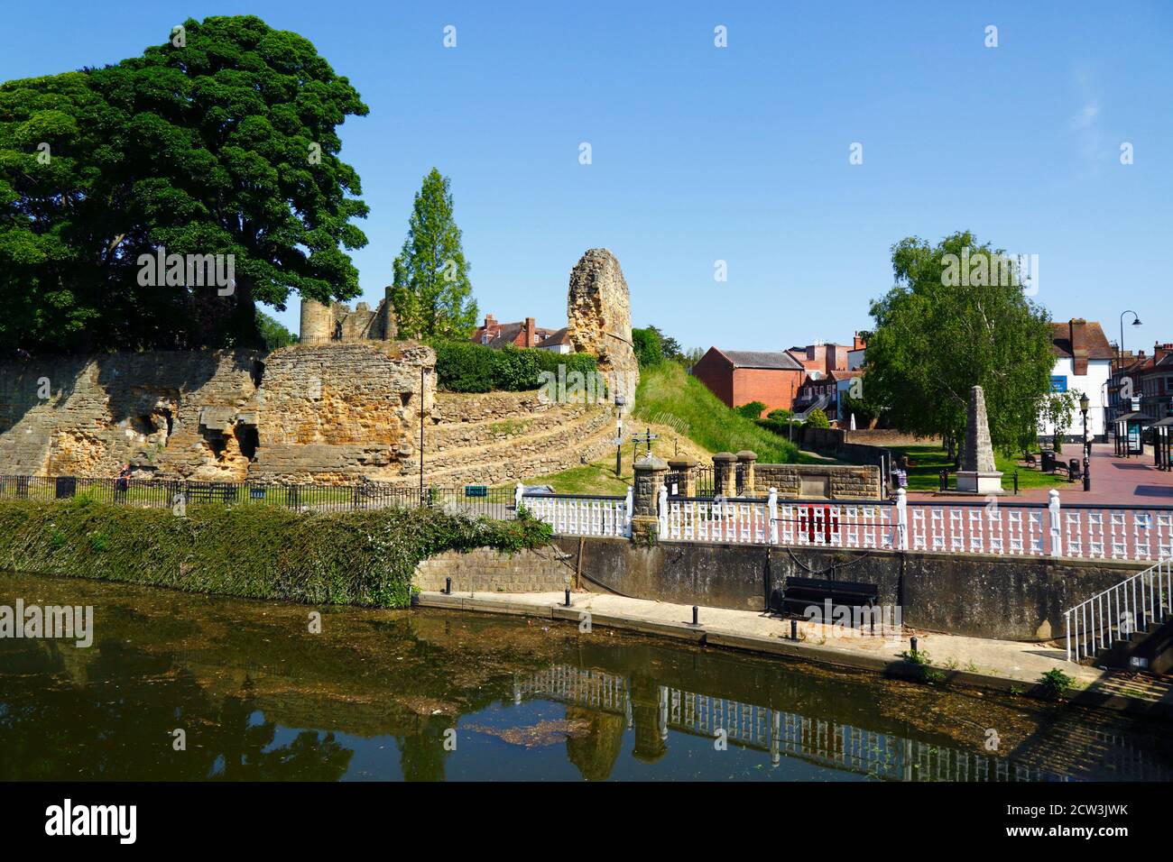 Walls of Tonbridge Castle reflected in River Medway, High Street on far ...