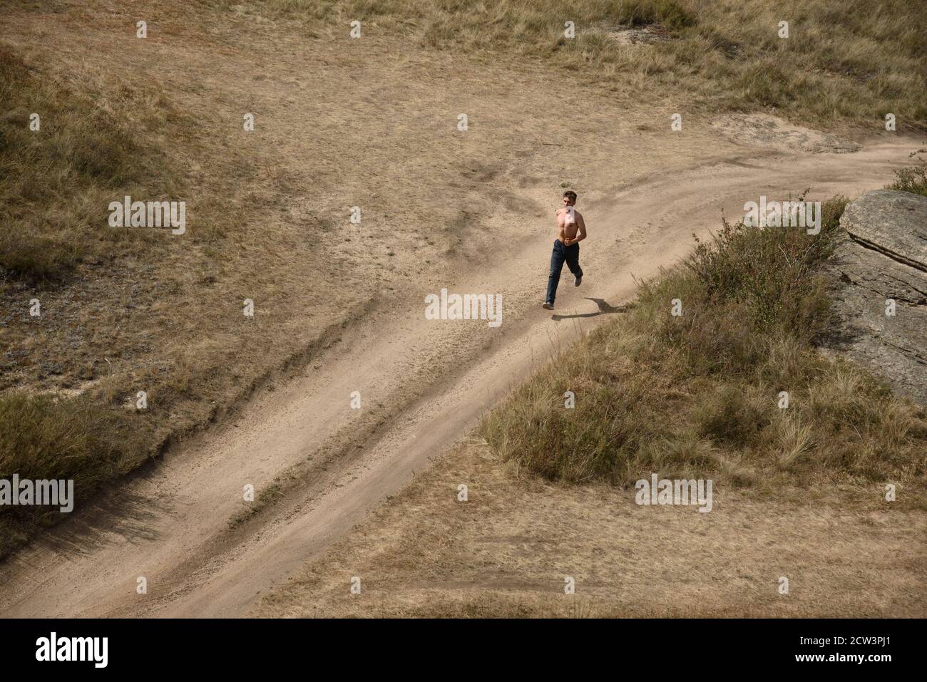 A young man runs on a dirt road. View from above Stock Photo - Alamy