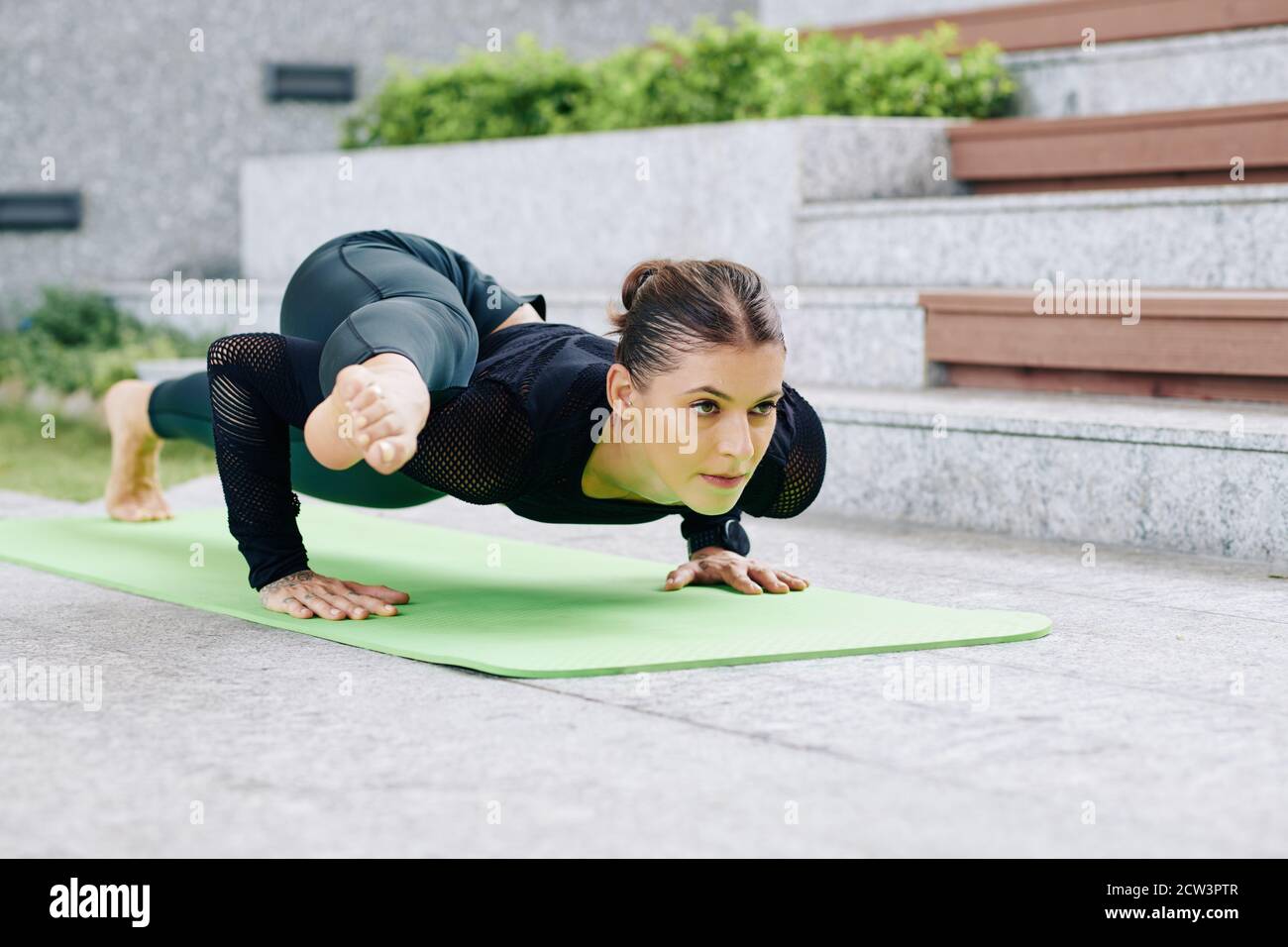 Flexible woman doing plank Stock Photo - Alamy