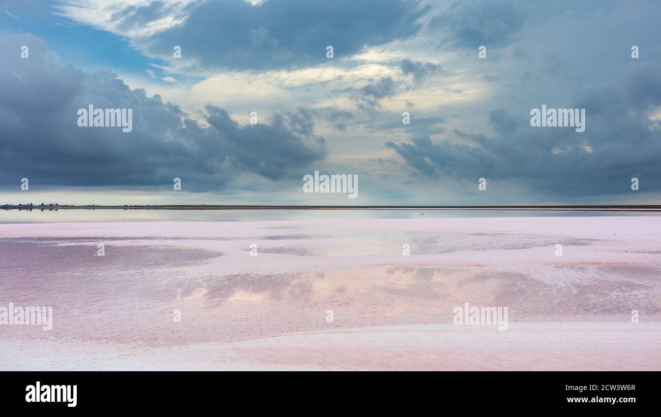 Salt pink lake reflective wet surface with gray high layered epic ...