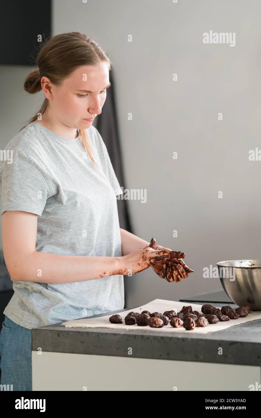 Cheerful girl making chocolate truffle with copy space, shallow focus ...