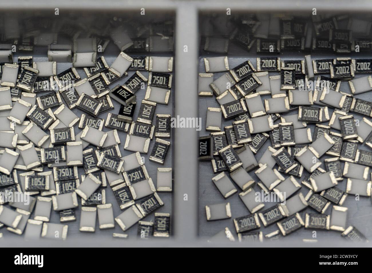 Grey scattered microscopic SMT surface mount chip resistors sorted in ...