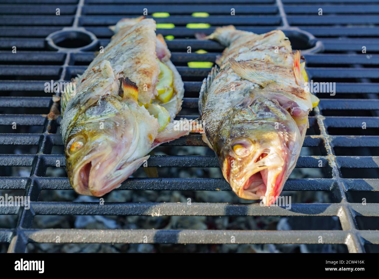 Grilled fresh fish. Cooking BBQ seafood on fire outdoors Stock Photo ...