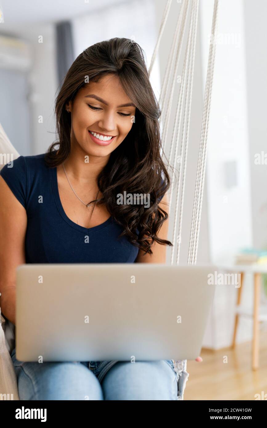 Happy beautiful woman using technology device to work, study at home ...