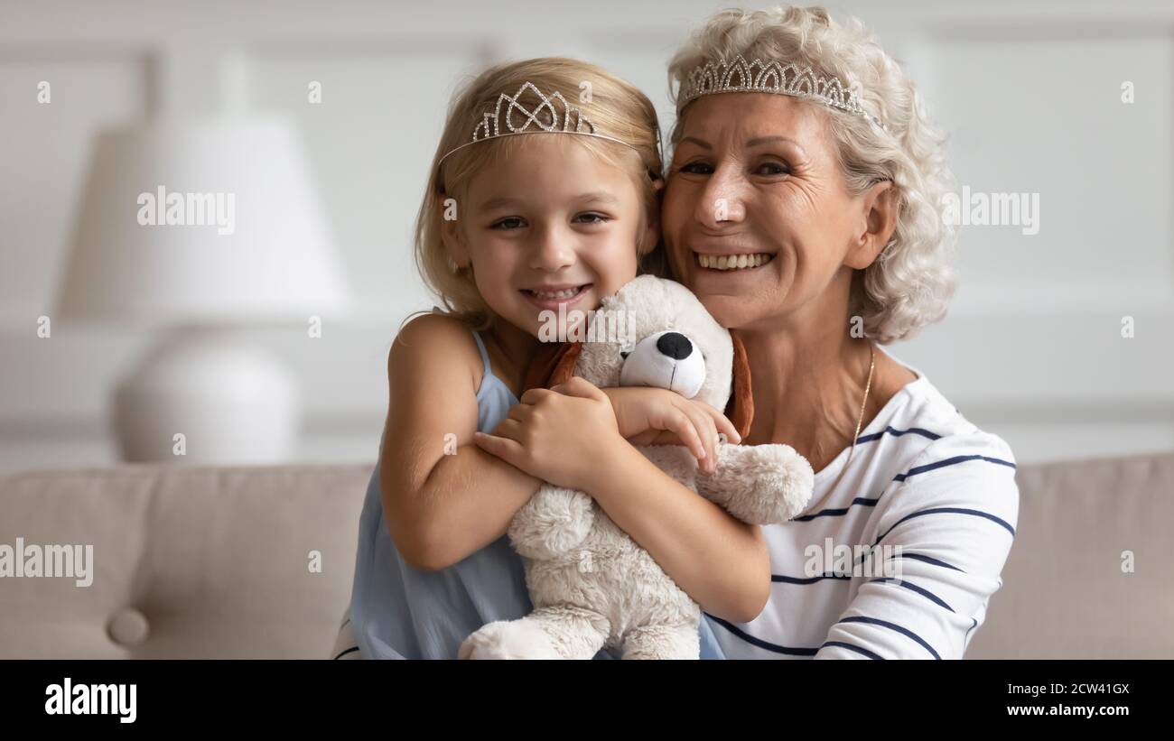 Little girl in crown posing in arms of elderly grandma Stock Photo - Alamy
