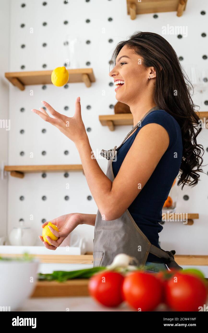 Beautiful woman having fun cooking in kitchen at home Stock Photo - Alamy