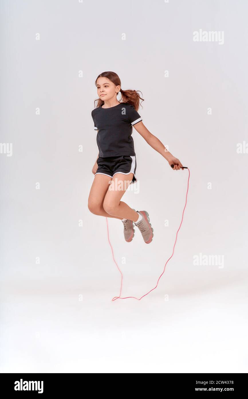 Healthy and active. Full-length shot of a cute teenage girl skipping ...