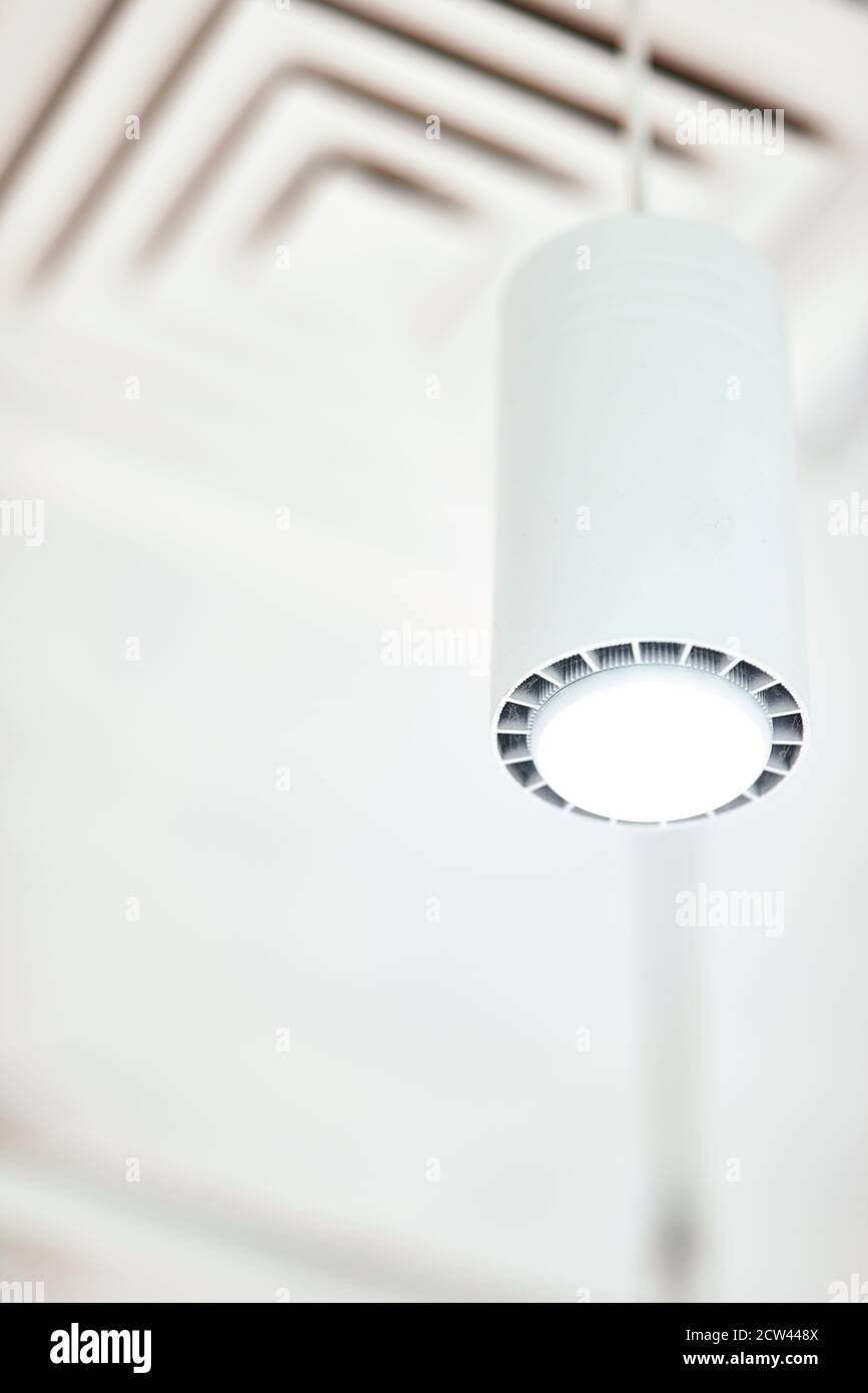 Pendant light. Close up of a modern white ceiling lamp shaped tube ...