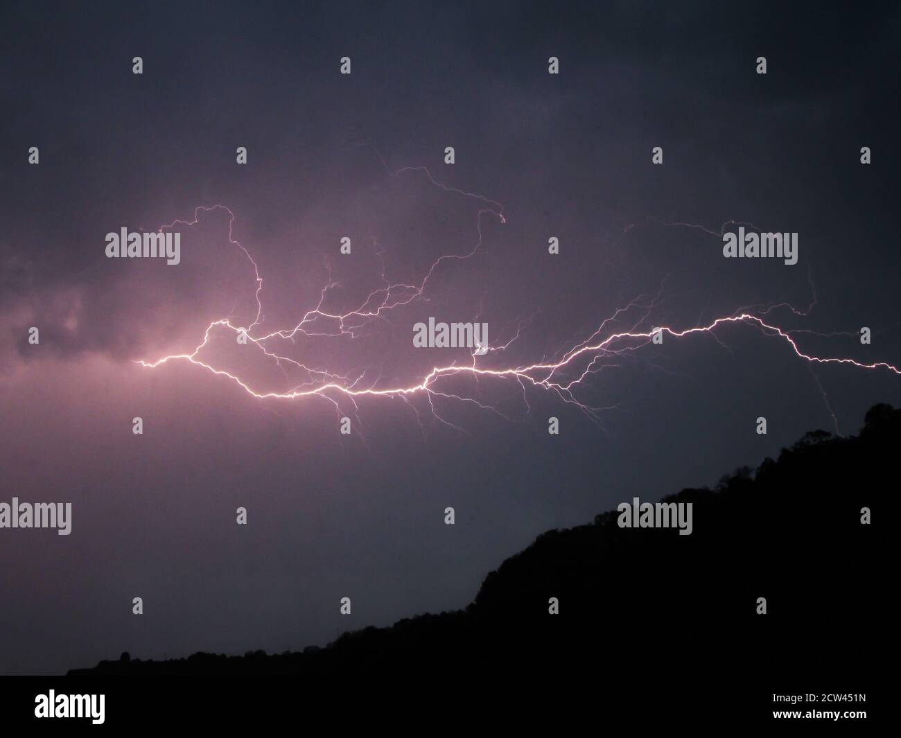 Horizontal lightning over a hill Stock Photo - Alamy