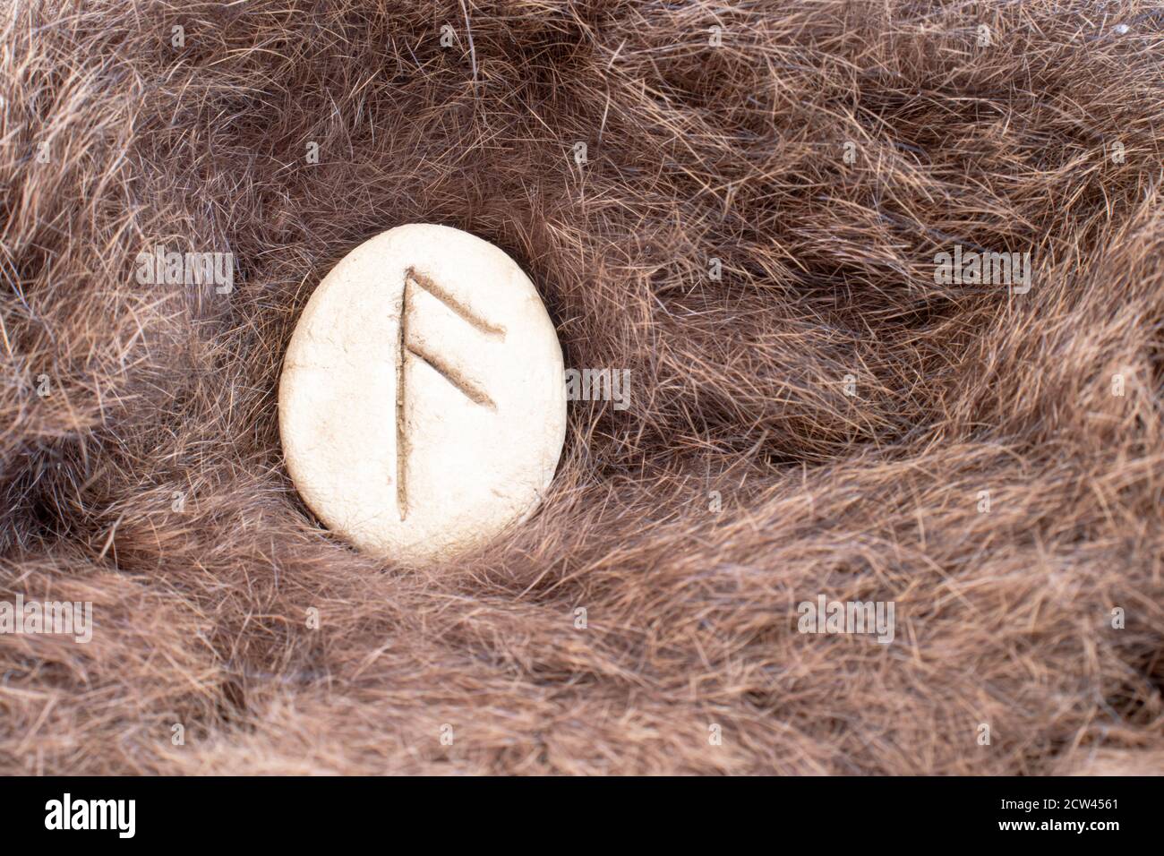 Ansuz Nordic stone rune on fur. Letter Aesc of the Viking alphabet ...