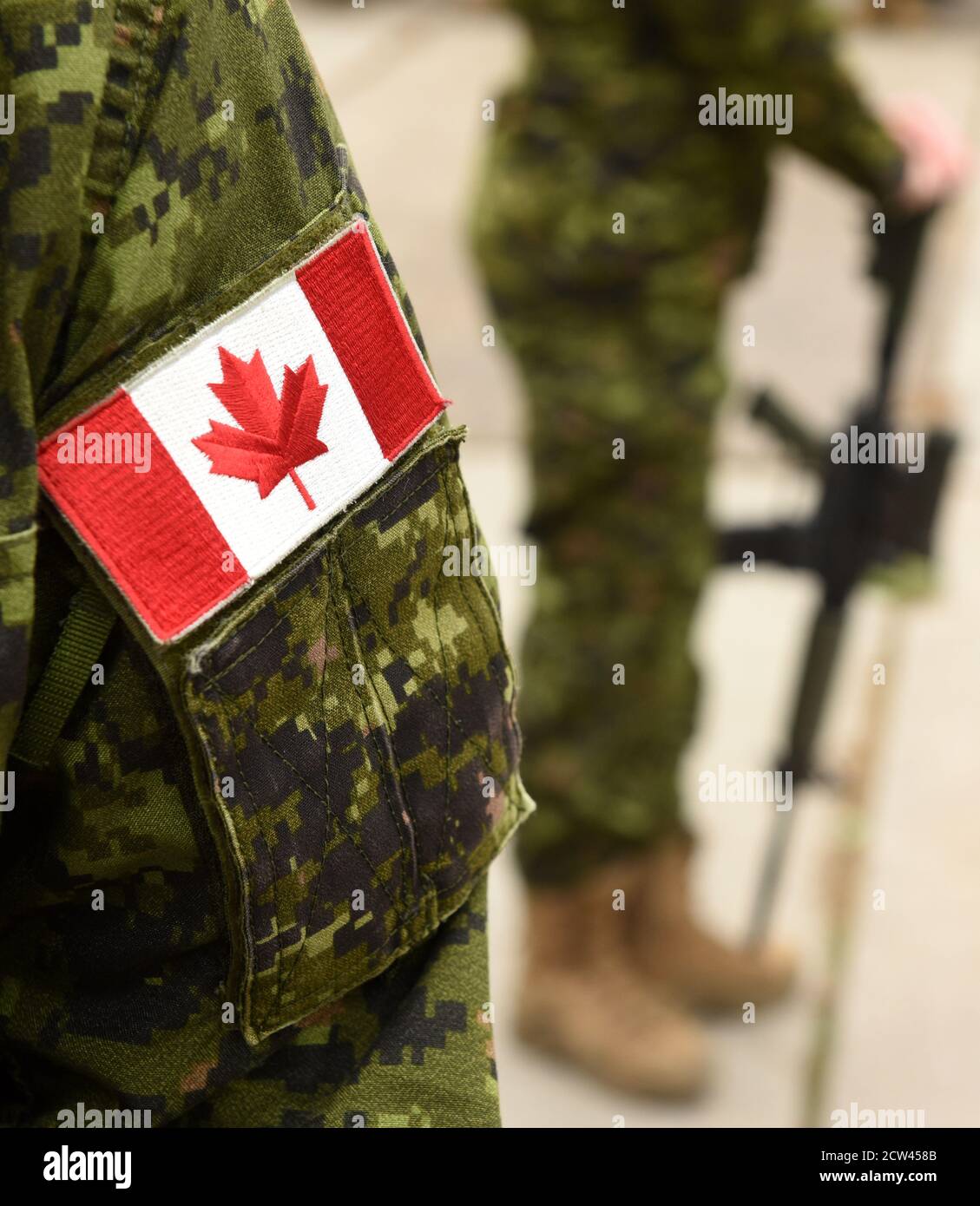 Flag of Canada on the military uniform and soldier with weapon on the ...