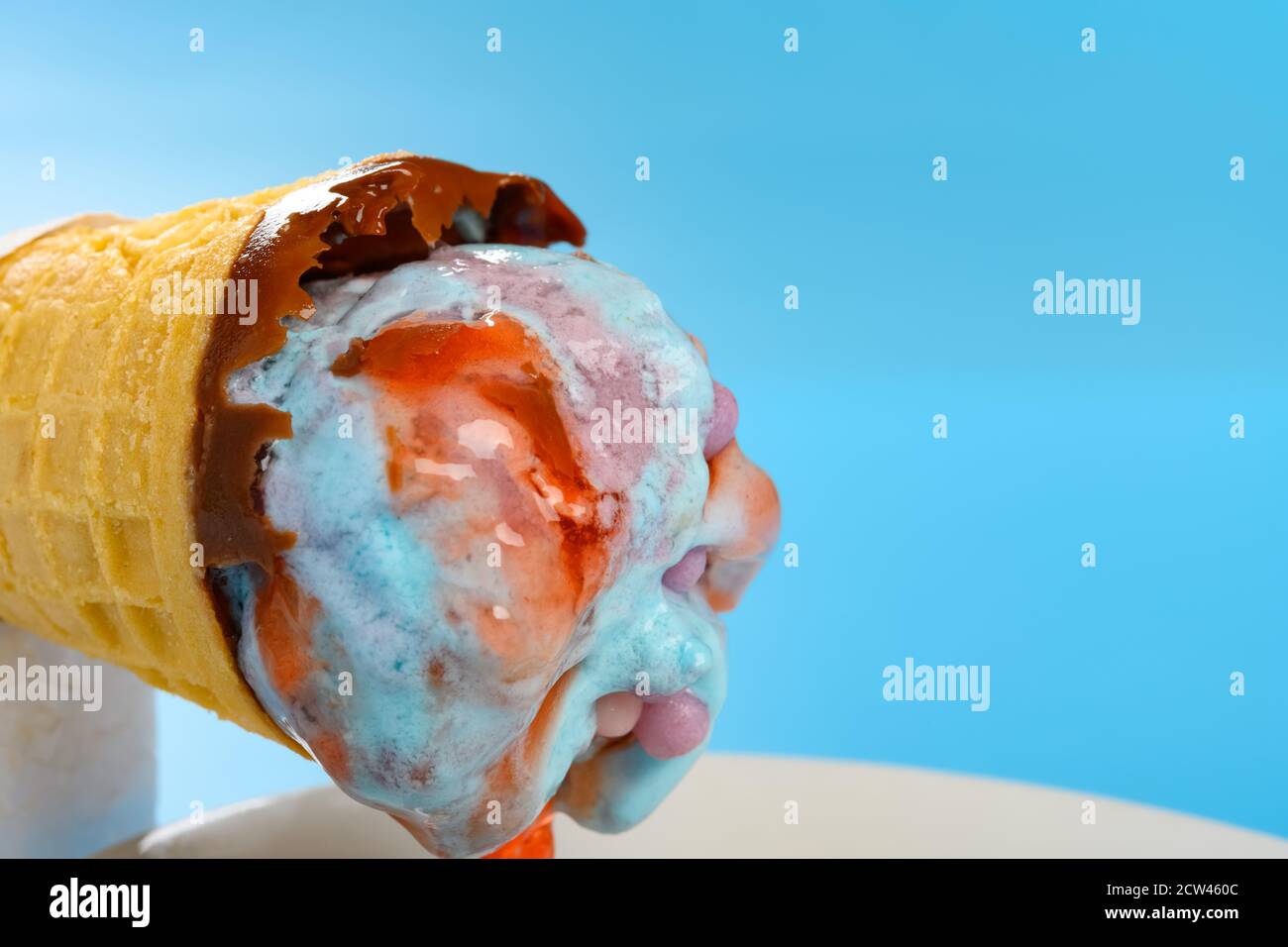 marshmallow and raspberry flavor ice cream cone in a melting process on ...