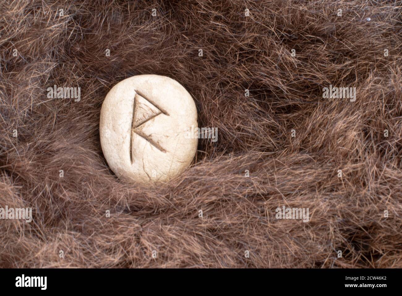 Raido or Raidho Nordic stone rune on fur. Letter Raed of the Viking ...